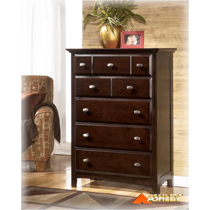 B294-46 Ashley Furniture Protege 5 Dwr Chest Merlot Finish